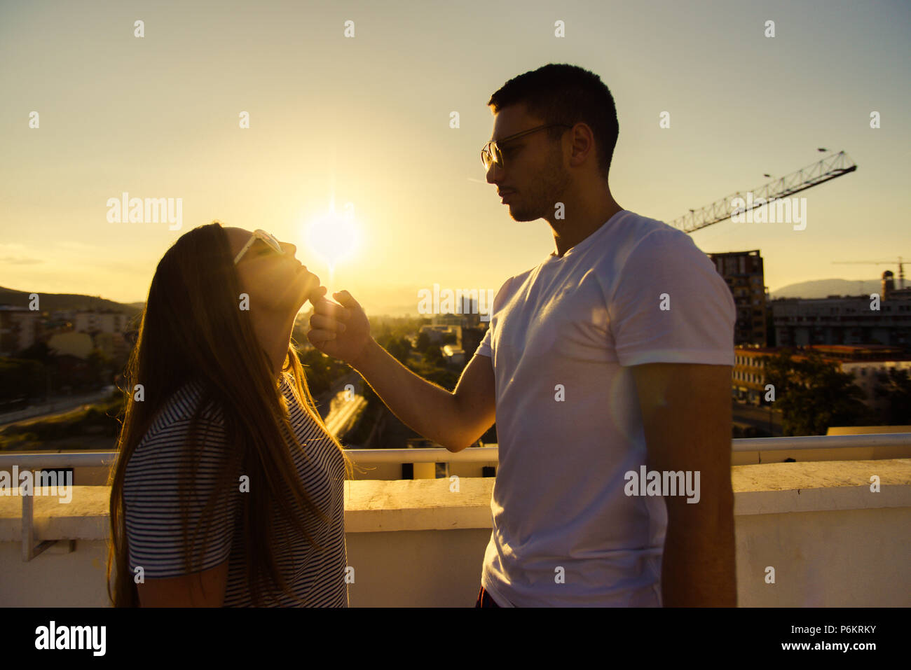 Portrait of romantic couple while making love on the terrace on sunset ...
