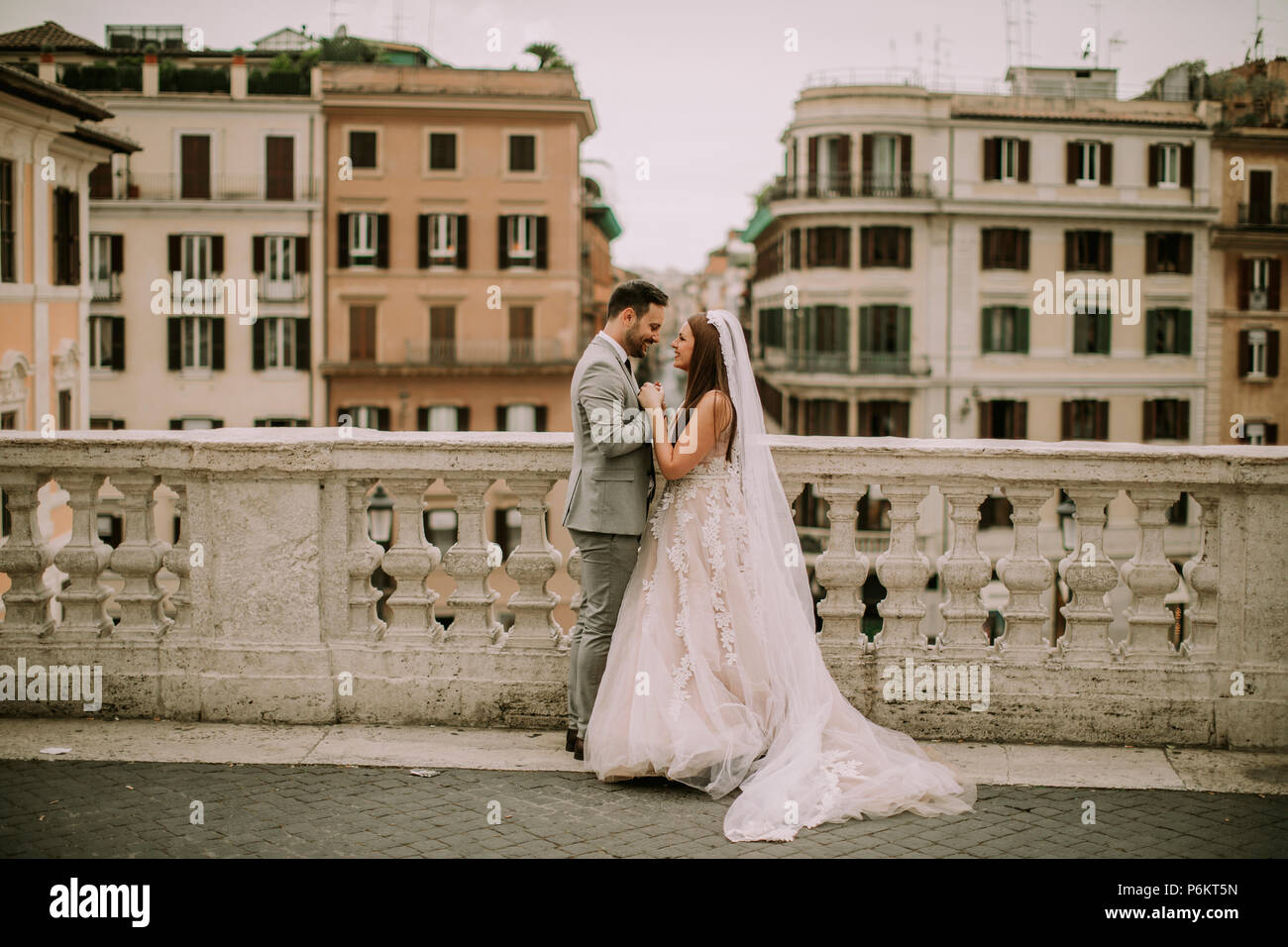 Young attractive newly married couple walking and posing in Rome with ...