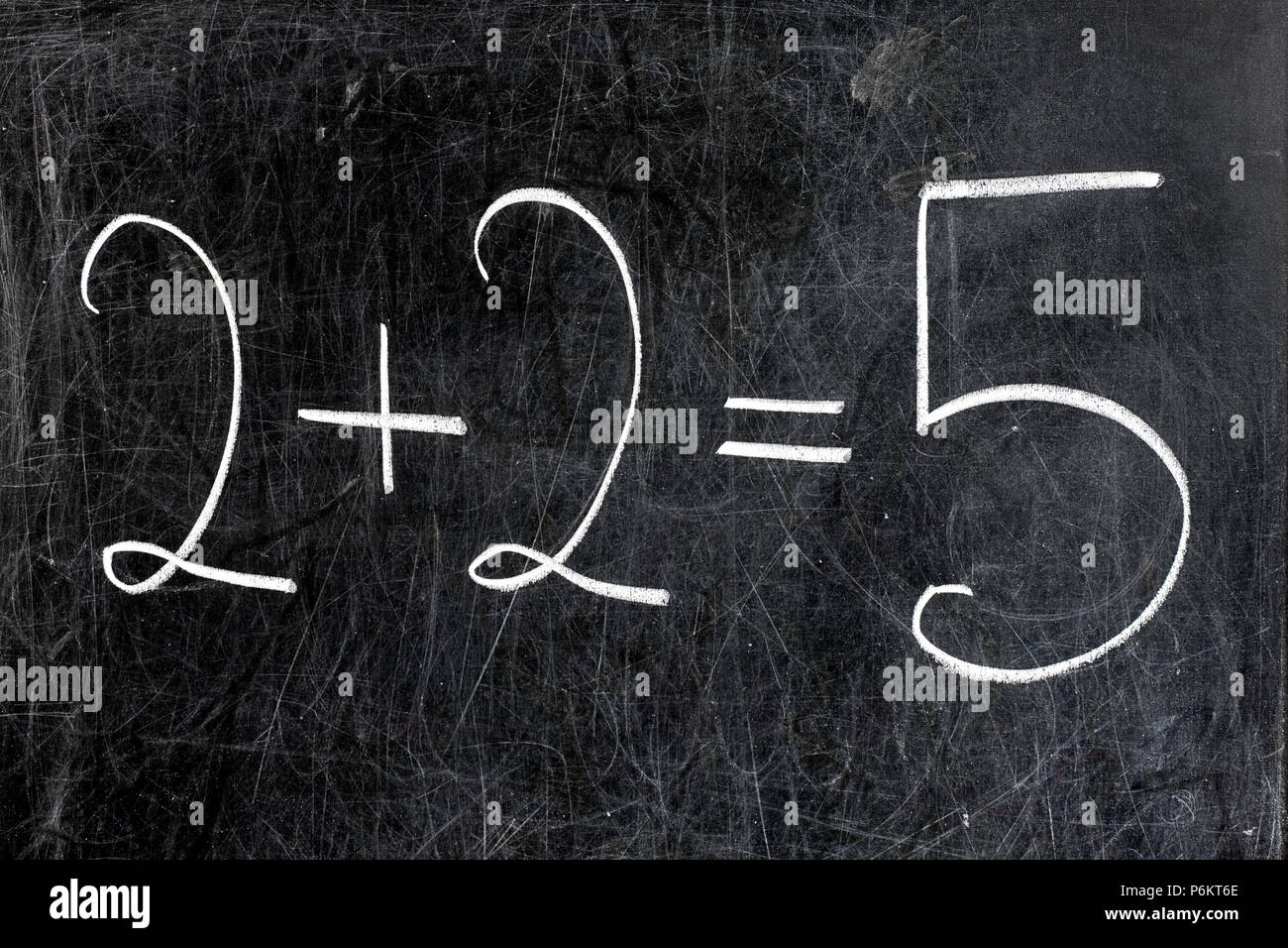 Two and two make five incorrect equation handwritten with white chalk ...
