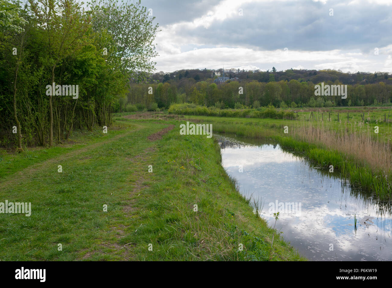 Hiking path through fields next to river Stock Photo - Alamy