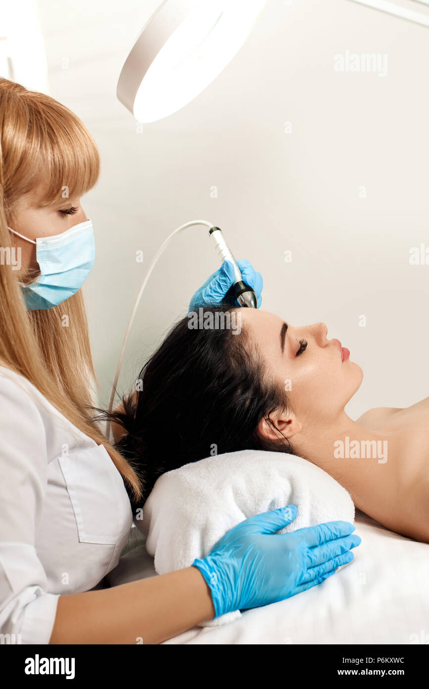 Beautician makes cleaning of face in spa salon Stock Photo - Alamy