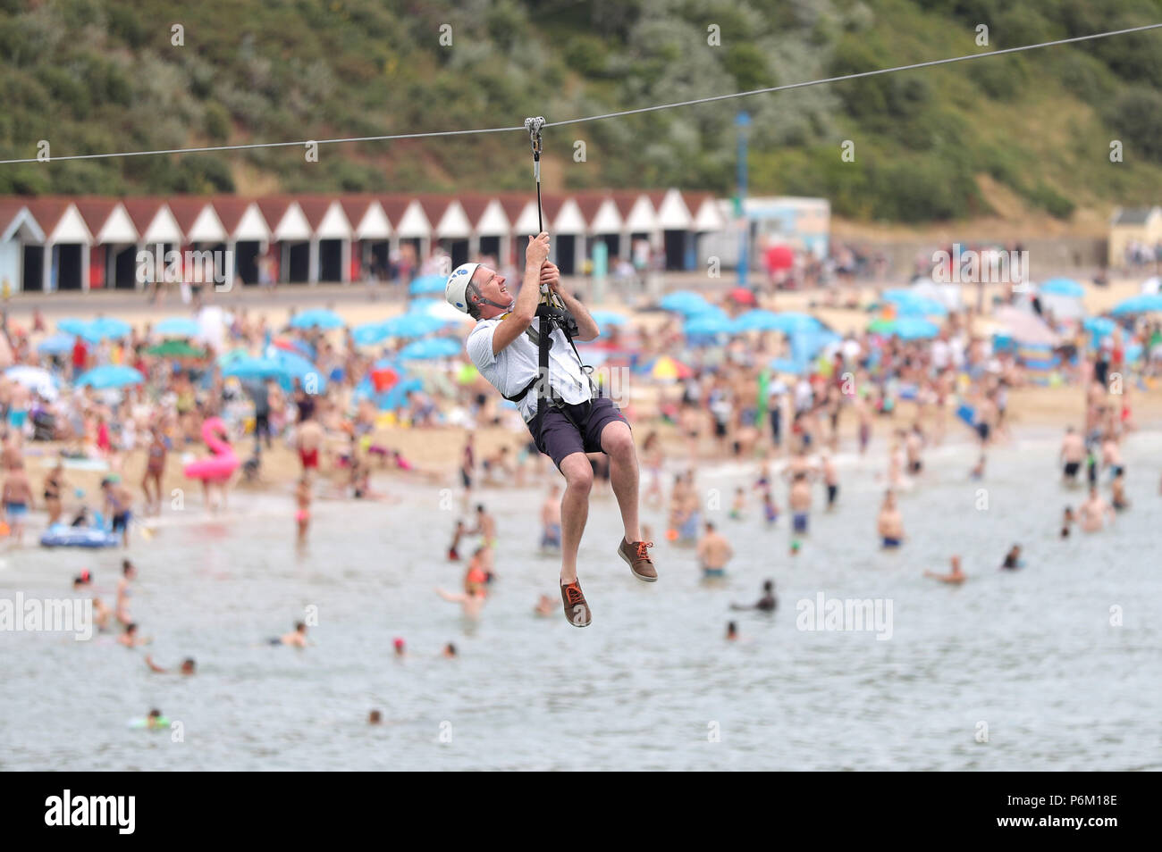 A person zip lines from Bournemouth pier as they enjoy the warm weather ...