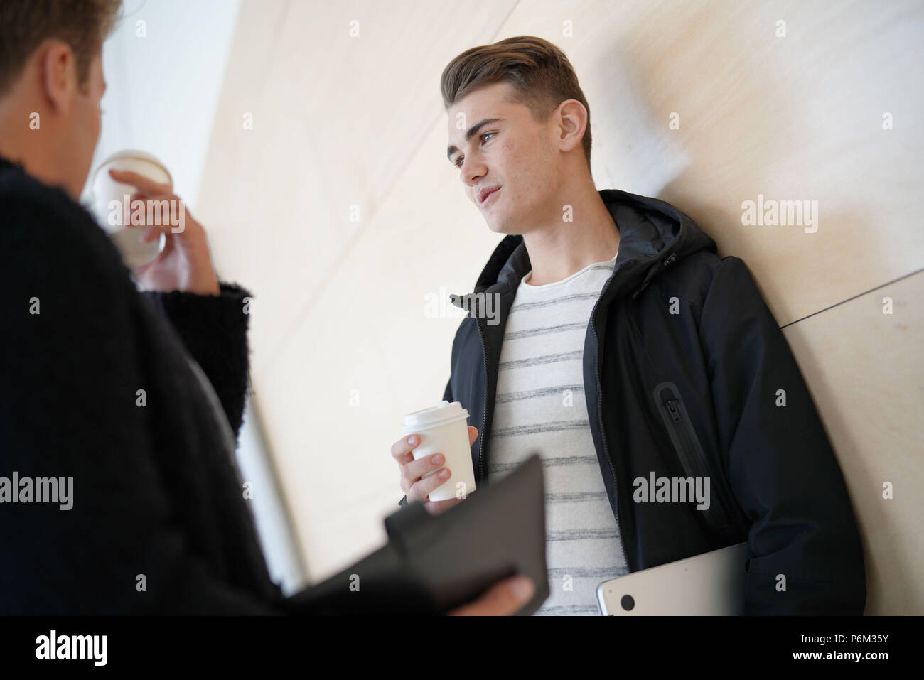 Friends gathering and talking in school hall Stock Photo - Alamy