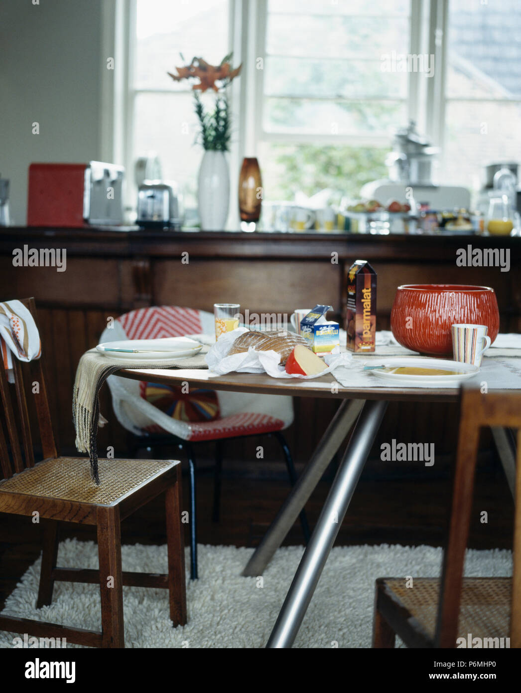 Cluttered table in modern kitchen with brown fitted units Stock Photo ...