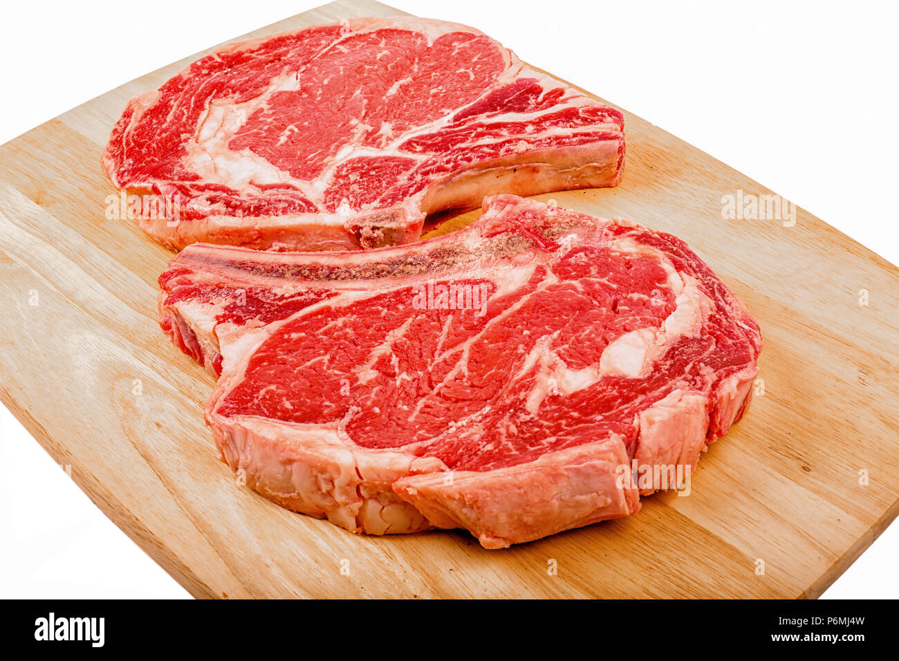 Raw rib steaks on a cutting board Stock Photo - Alamy