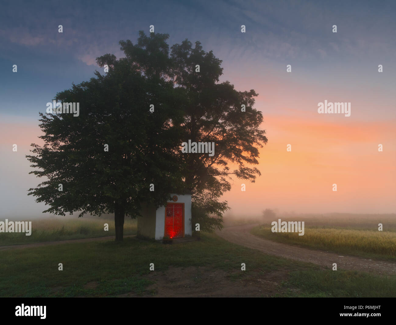 Colorful landscape with little chapel, trees on green field at sunrise ...