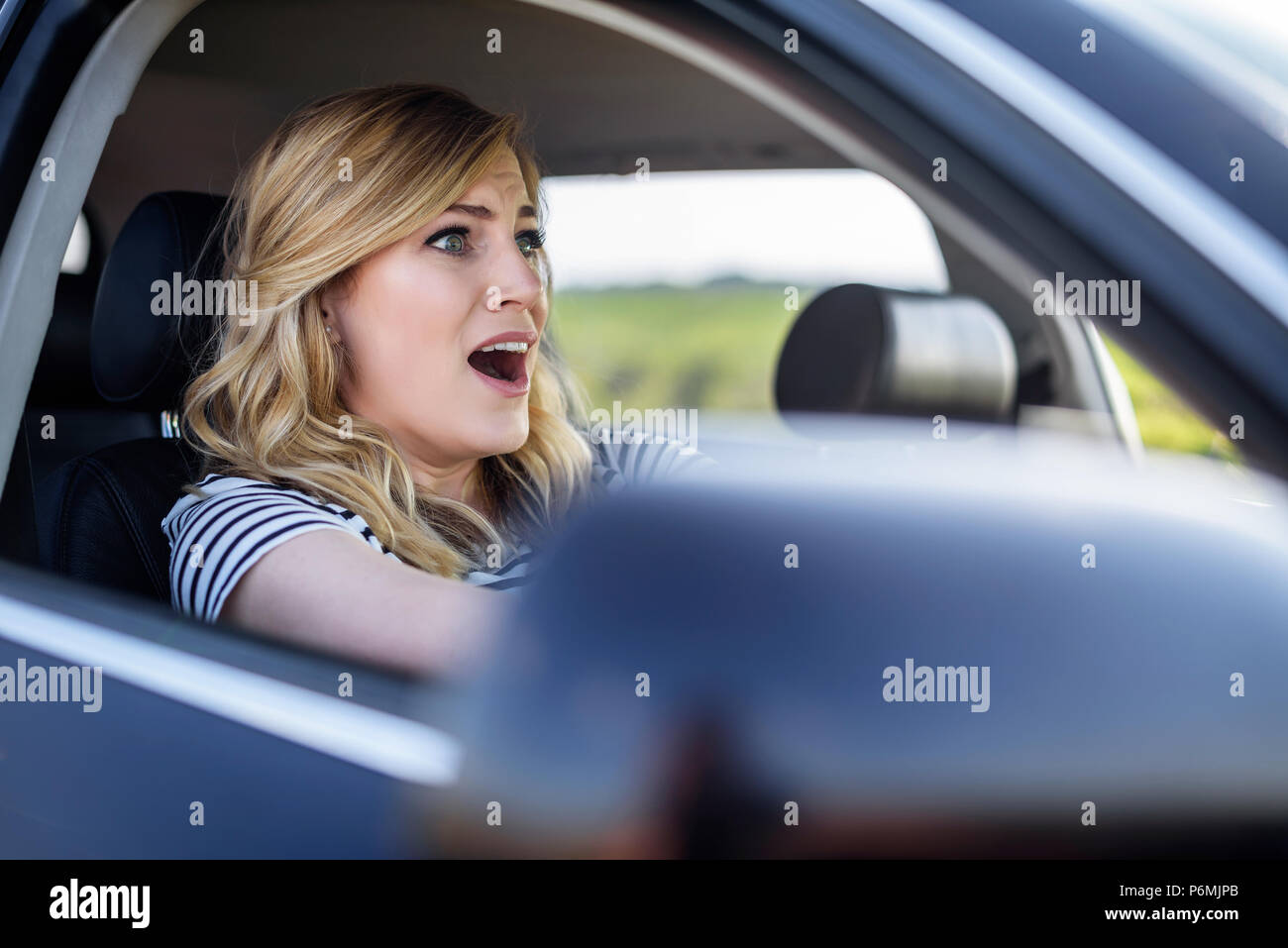 The woman driving the car in a panic Stock Photo - Alamy