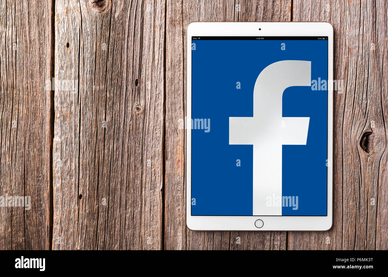 Ipad pro with social network Facebook on the screen, on a wooden table ...