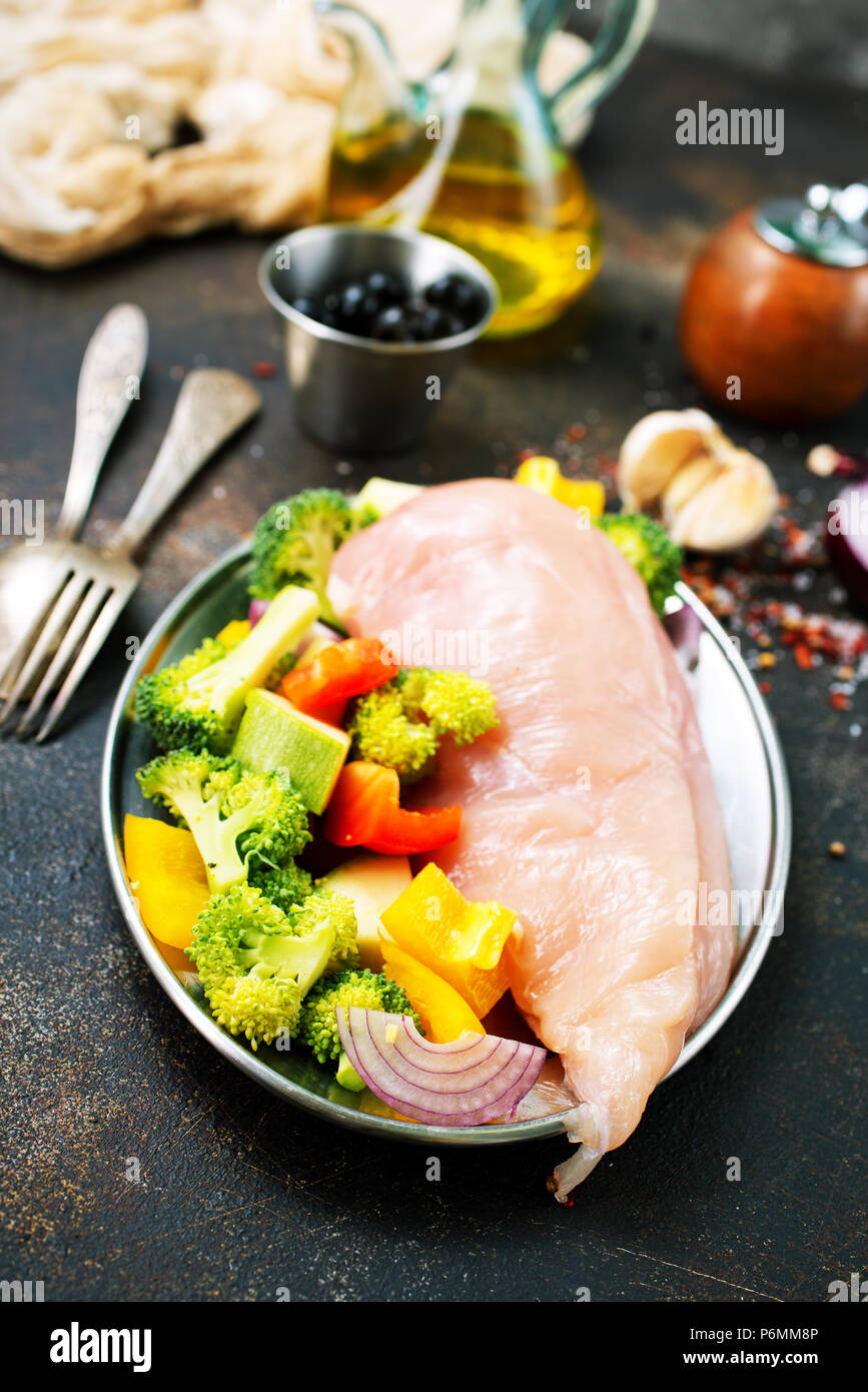 raw chicken fillet with fresh vegetables on plate Stock Photo - Alamy