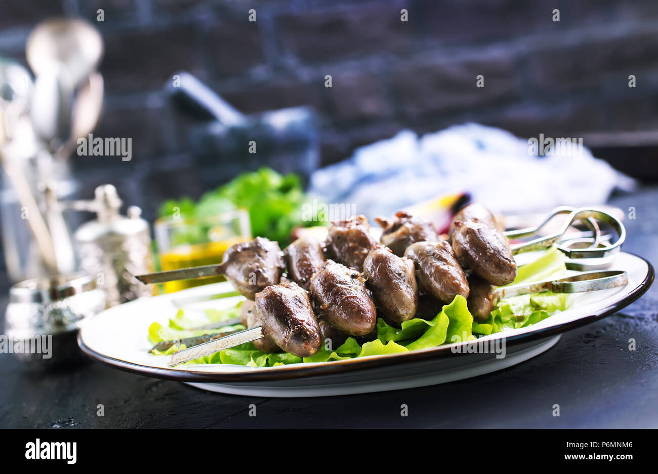 Fried hearts with spice. Chicken hearts kebab with salad on a plate top ...