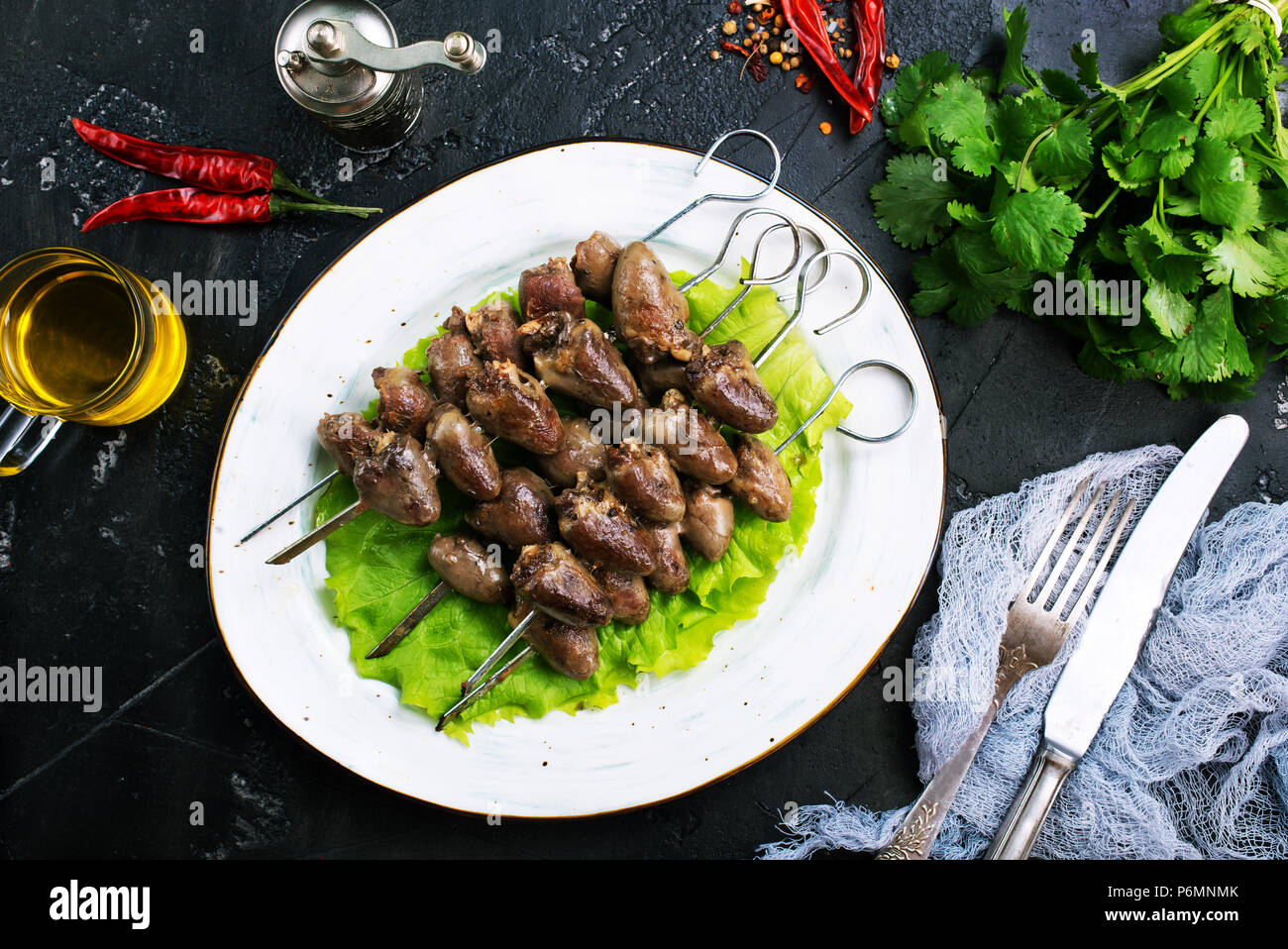 Fried hearts with spice. Chicken hearts kebab with salad on a plate top ...