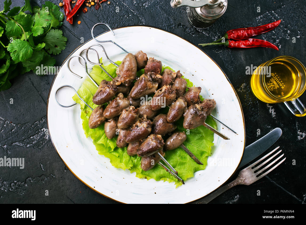 Fried hearts with spice. Chicken hearts kebab with salad on a plate top ...