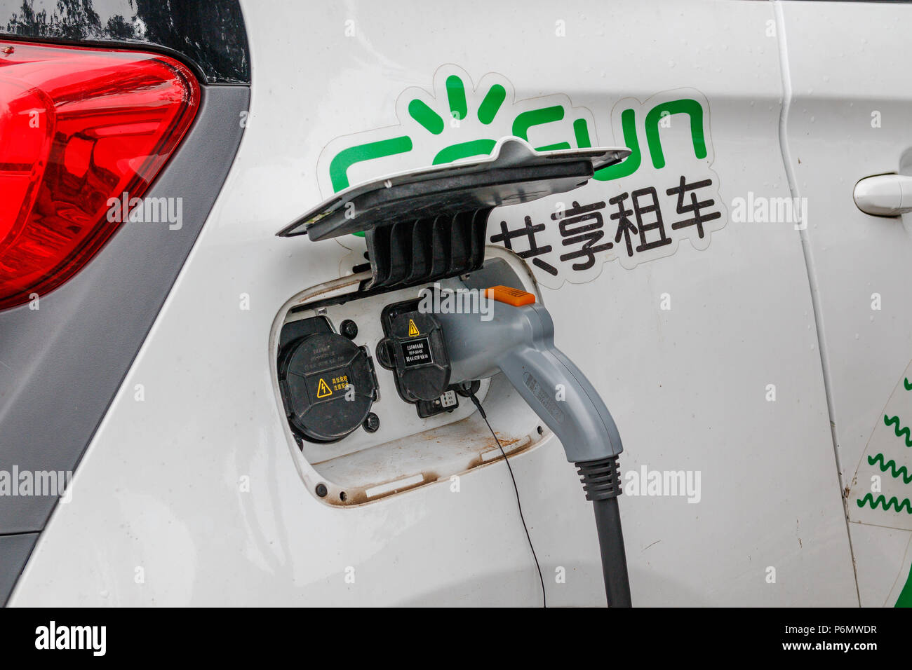 Charging an electric car with the power cable supply plugged from ...