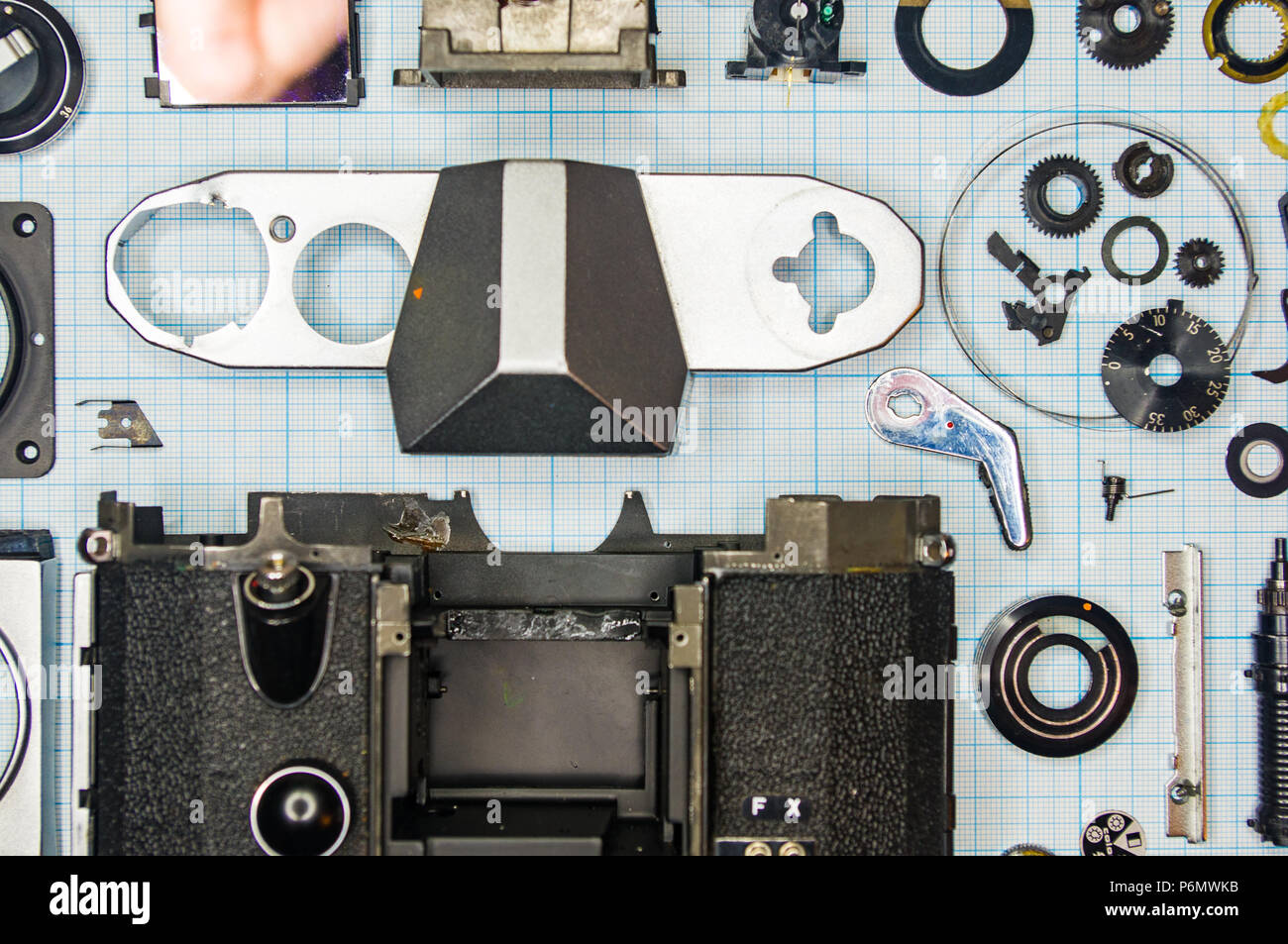 parts are completely disassembled old retro film SLR camera on graph ...