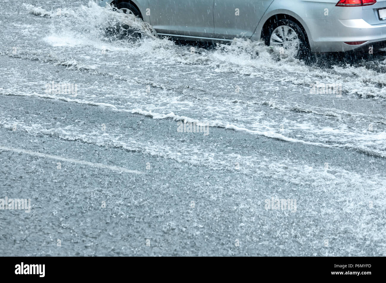 flooded street roads. car driving through water puddle and spraying ...