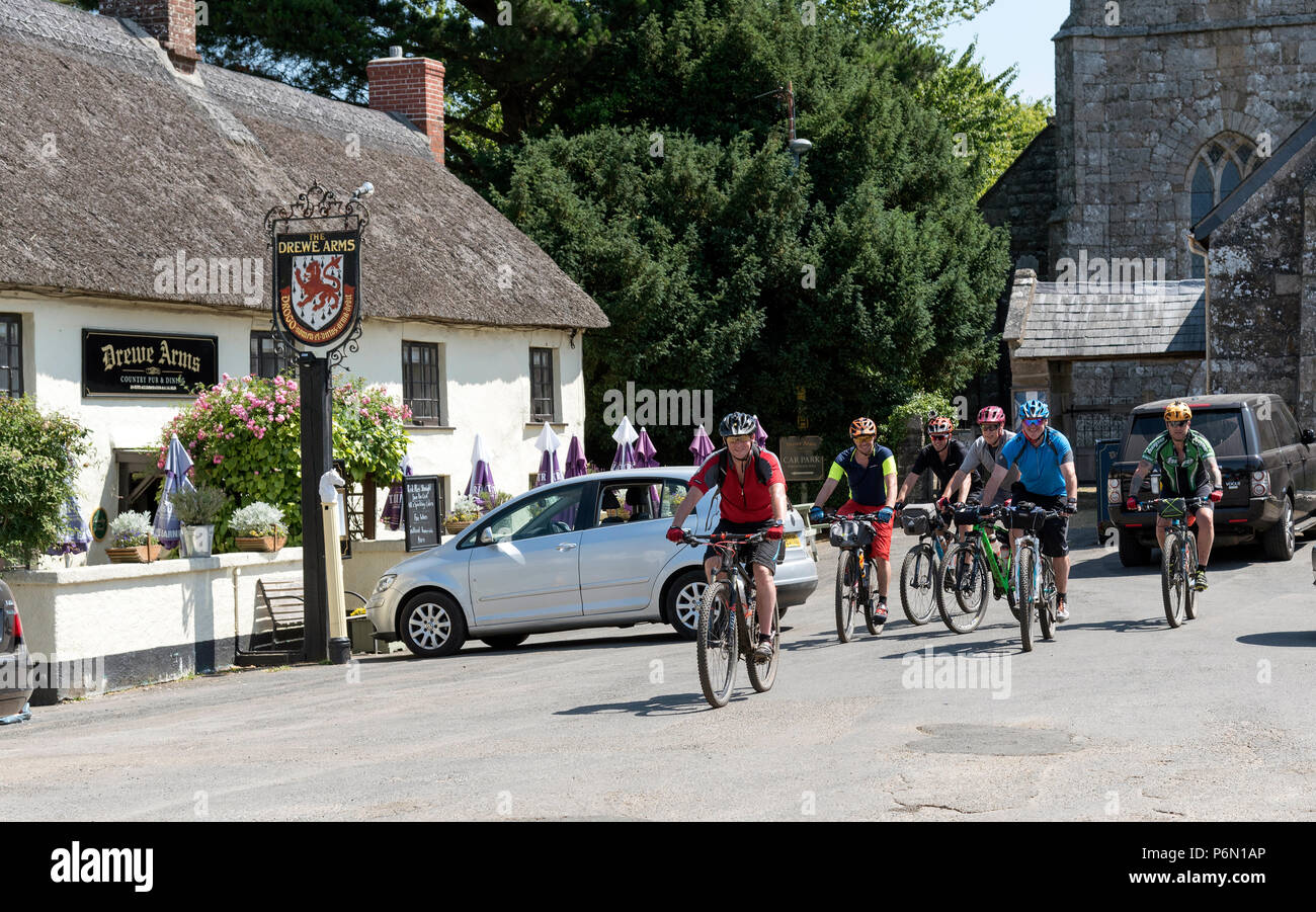 Drewsteignton, Devon, England, UK. Cyclists riding through this scenic ...