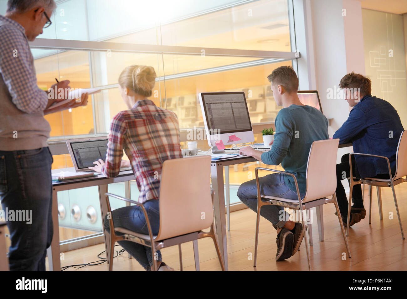 Teacher with students in computing class Stock Photo - Alamy