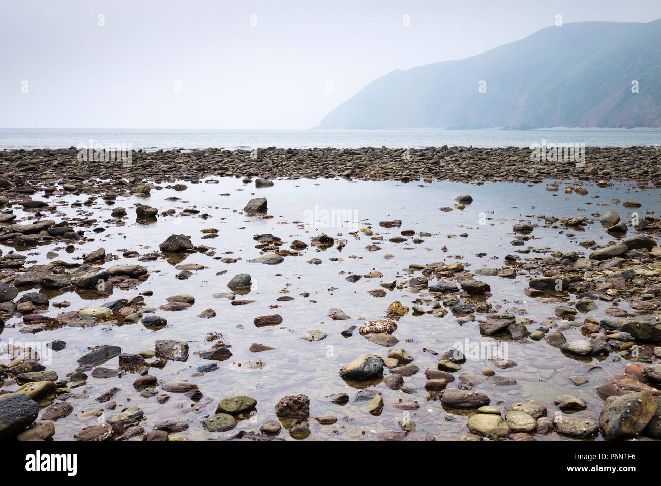 The rocky beach at Lynmouth, North Devon, with reflection and view ...