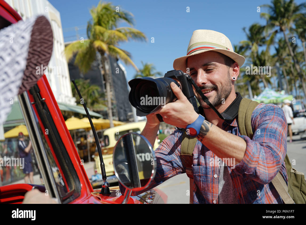 Photographer taking pictures of model sitting in old fashioned pick-up ...