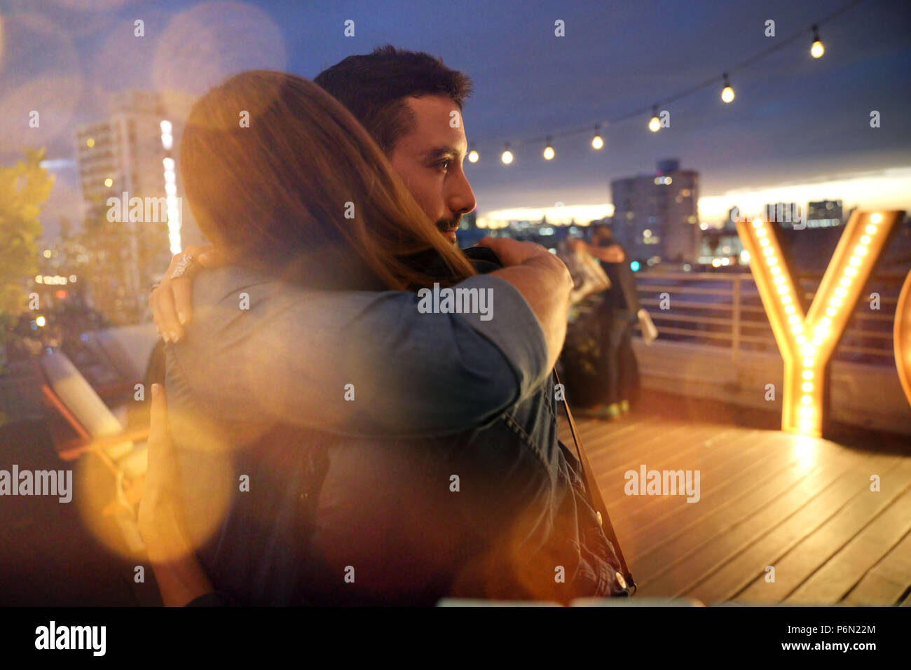 Couple hugging each other on rooftop at night Stock Photo - Alamy