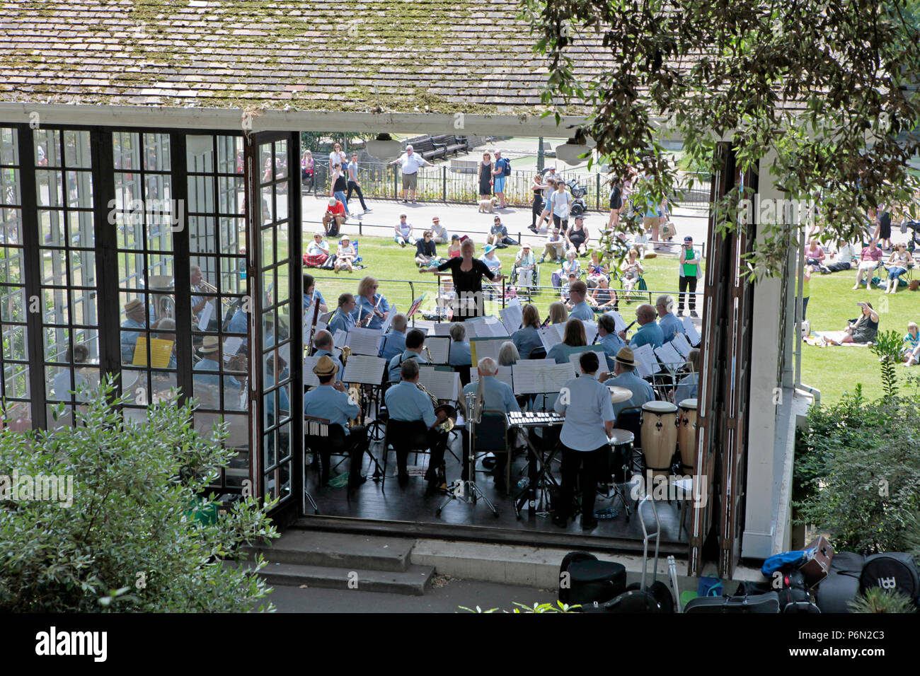 a conductor conducting a band in a traditional bandstand in the park at ...