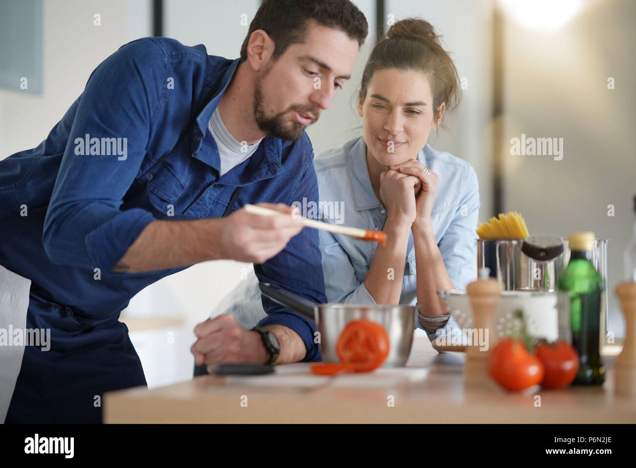 Couple at home having fun cooking together Stock Photo - Alamy