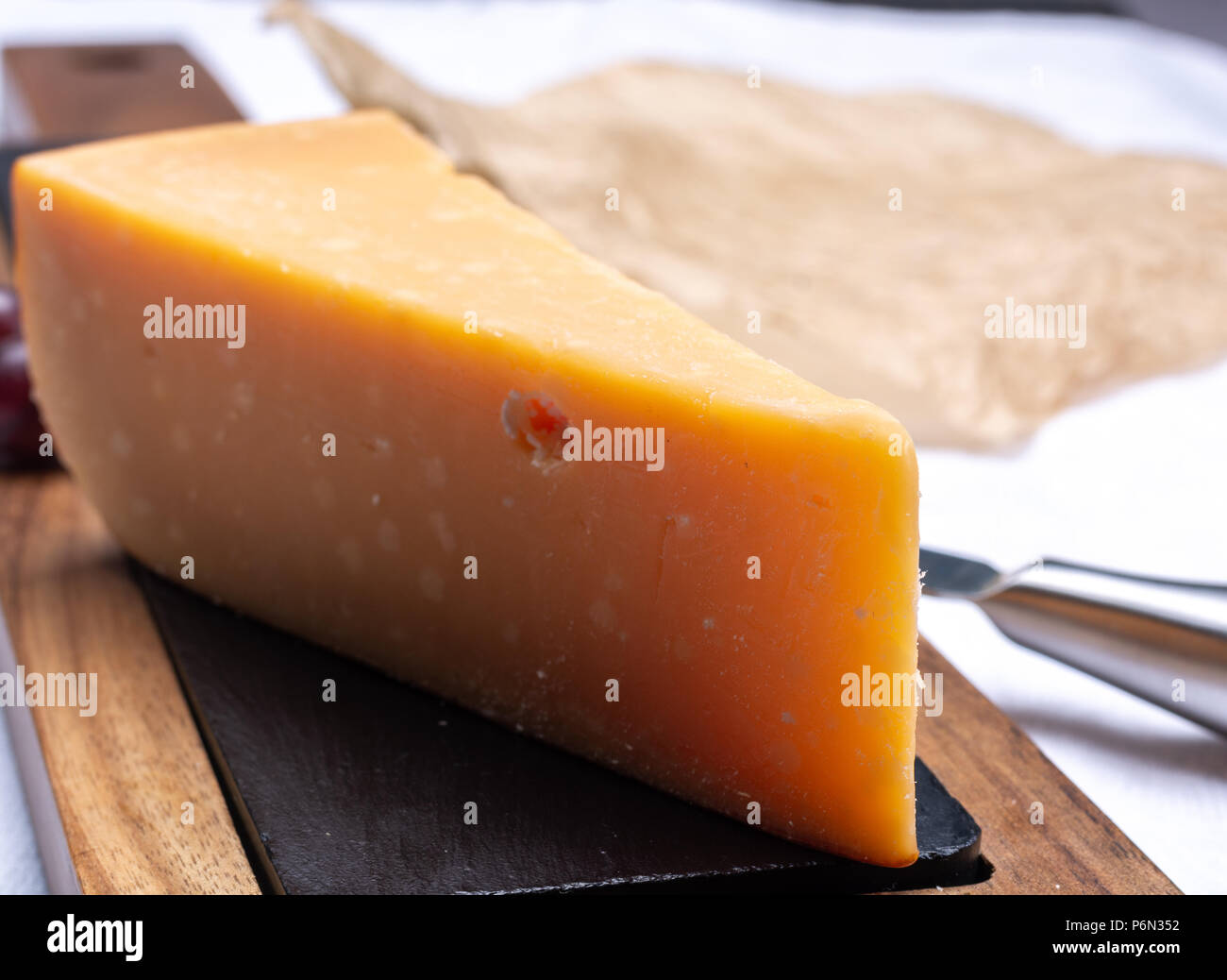 Piece of hard matured 3 years old dark yellow cheese close up Stock ...