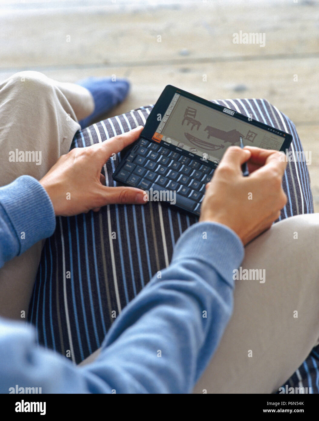Close-up of man's hands using small laptop to create drawings FOR ...