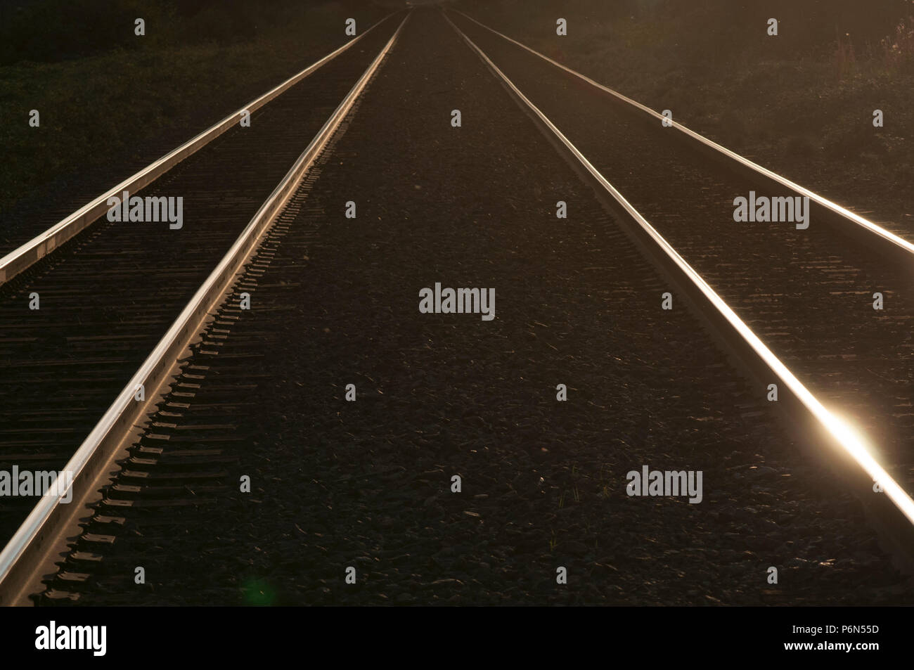 Converging railway tracks; dark background with reflection Stock Photo ...