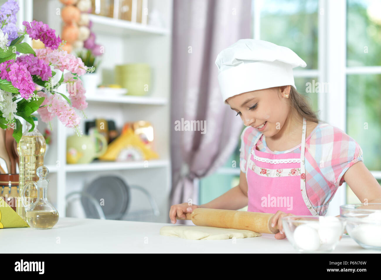 Cute little girl making dinner Stock Photo - Alamy