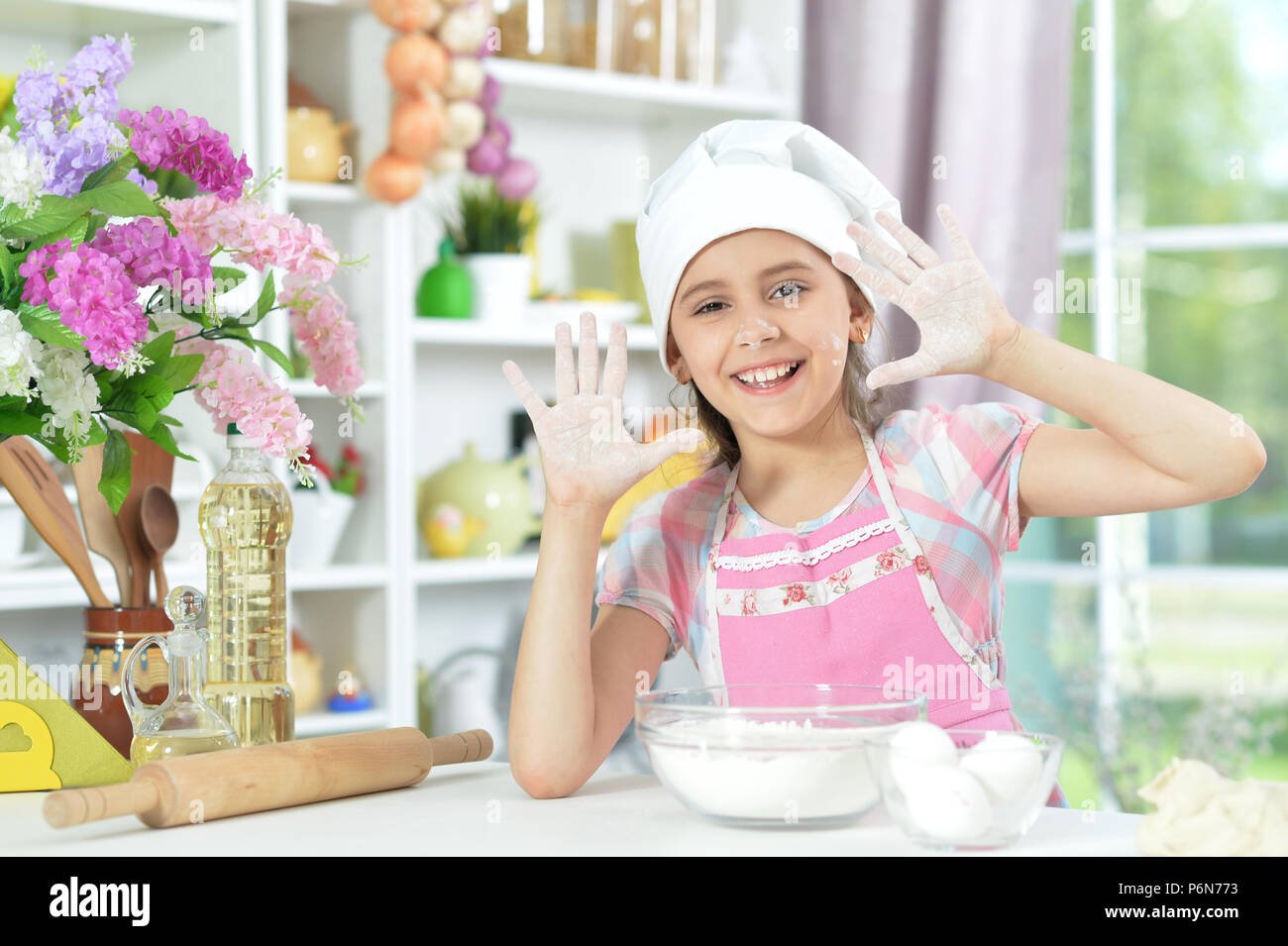 Cute little girl making dinner Stock Photo - Alamy