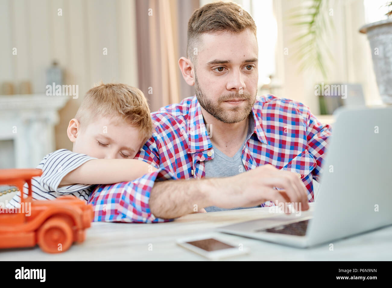 Busy Dad Working at Laptop Stock Photo - Alamy
