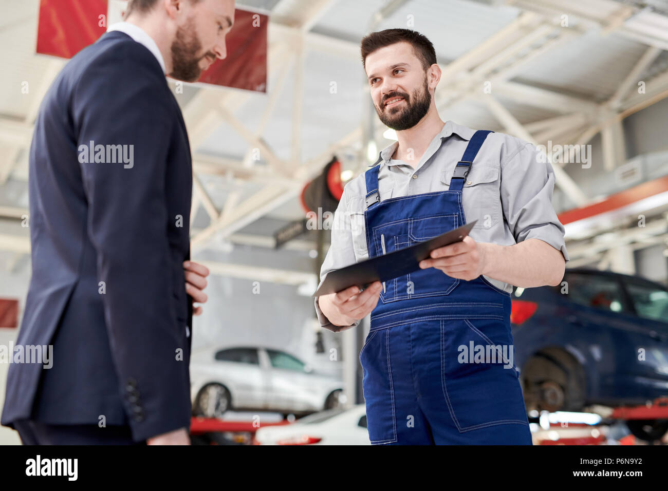 Smiling Mechanic Giving Contract to Client Stock Photo - Alamy
