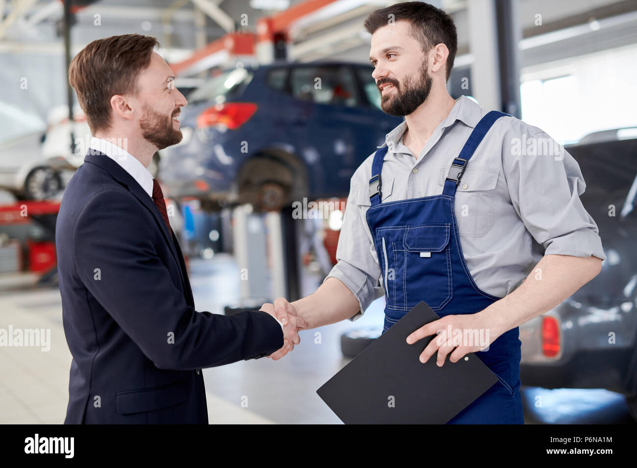 Mechanic Shaking Hands with Businessman Stock Photo - Alamy