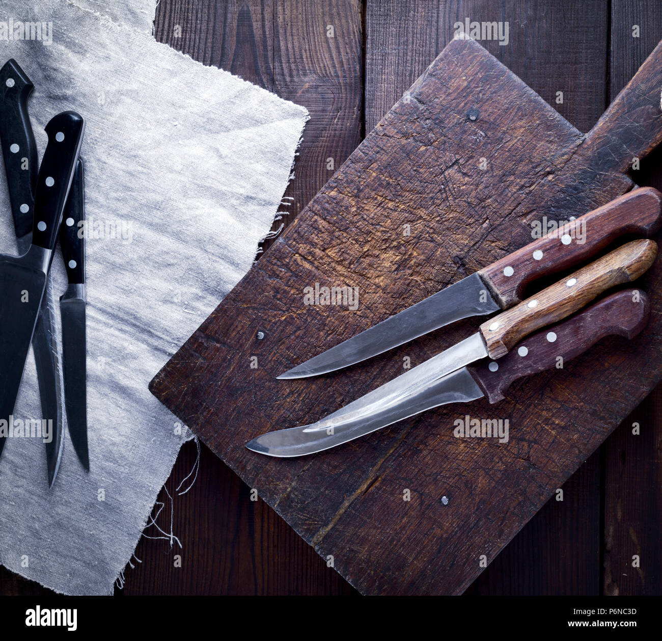 used kitchen knives and brown wooden cutting board, top view Stock ...