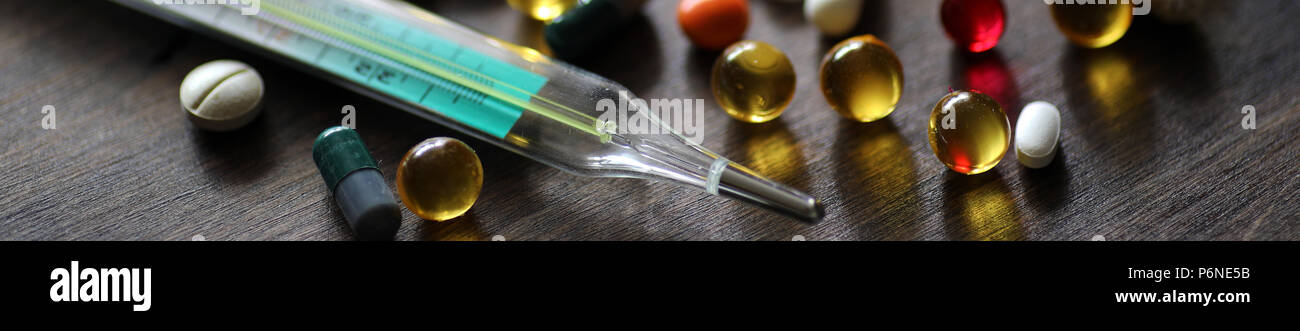 Different colored medications and tablets on a wooden texture table ...