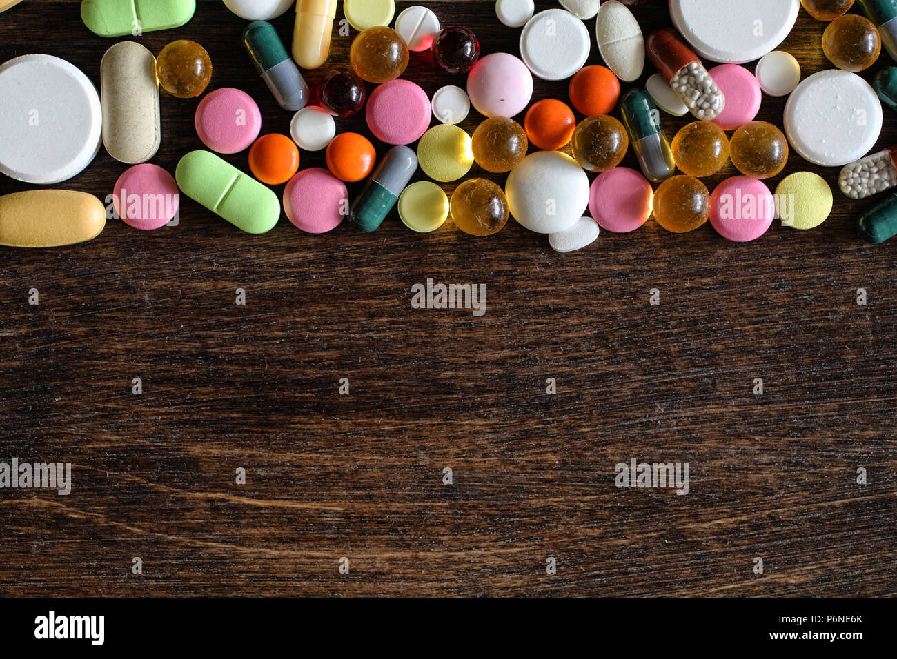 Medical background of various colorful medications on a textured wooden ...