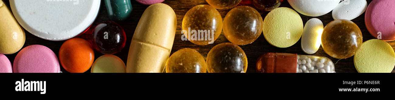 Medical background of various colorful medications on a textured wooden ...