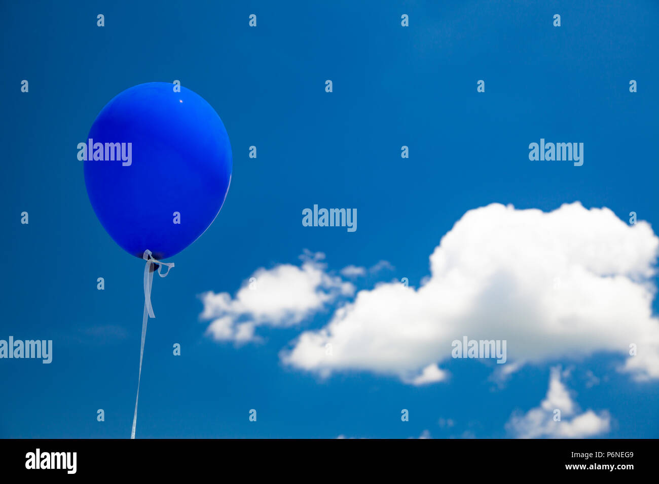 Blue baloon flying in the sky in summertime Stock Photo - Alamy