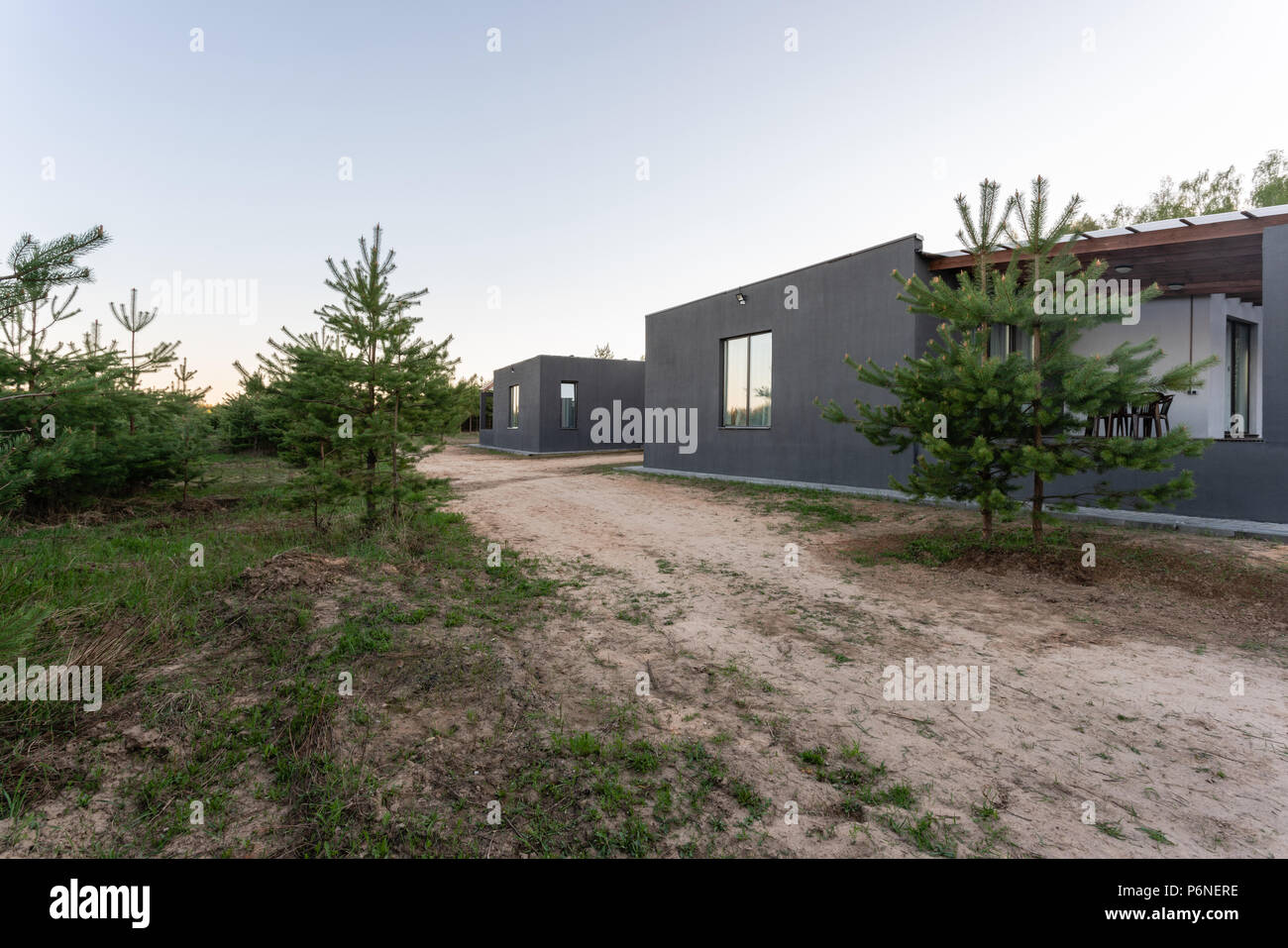 Side view of an open veranda in front of a modern forest cottage. Pine ...
