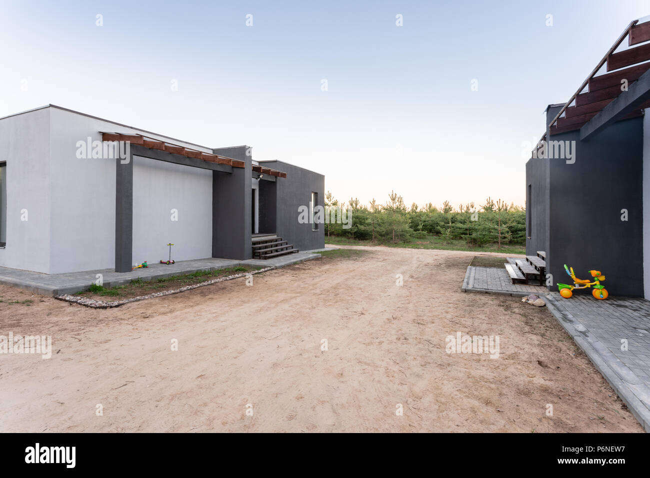 Side view of an open veranda in front of a modern forest cottage. Pine ...
