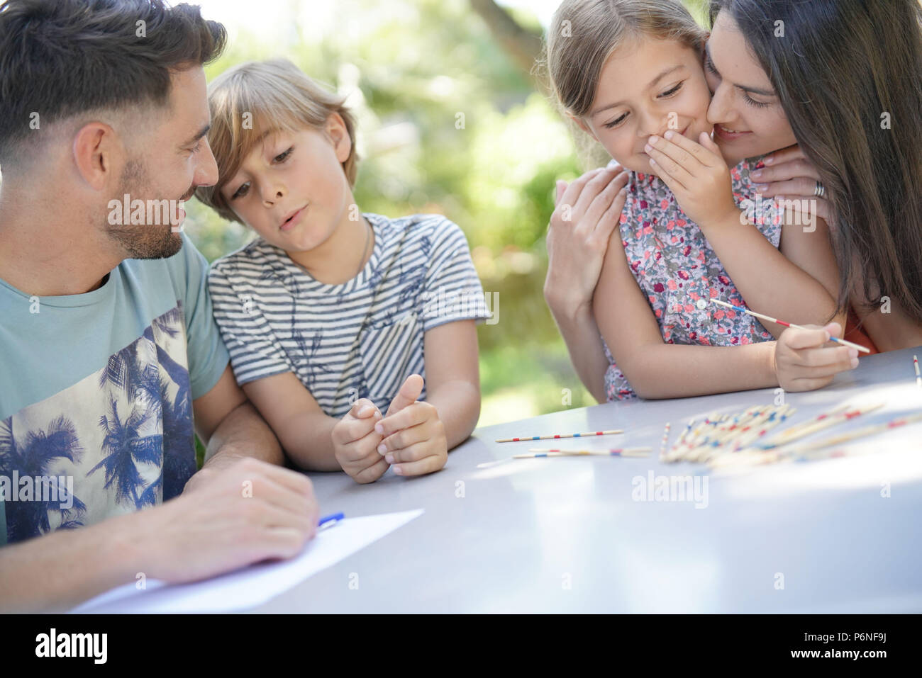 Happy family enjoying playing game together Stock Photo - Alamy