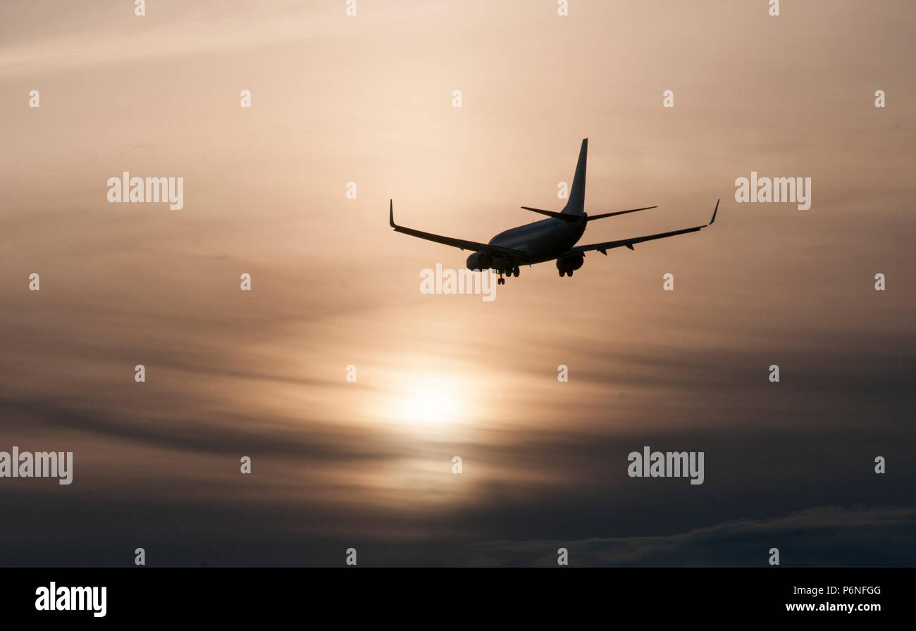 737 on final sunset approach to YVR with soft sunset as backdrop Stock ...
