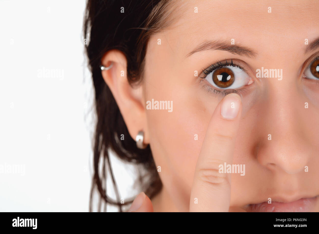 Closeup Of Female Face With Applying Contact Lens On Her Brown Eyes ...