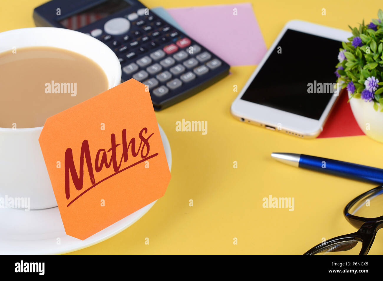Paper card with "maths" text and coffee with phone on a yellow ...