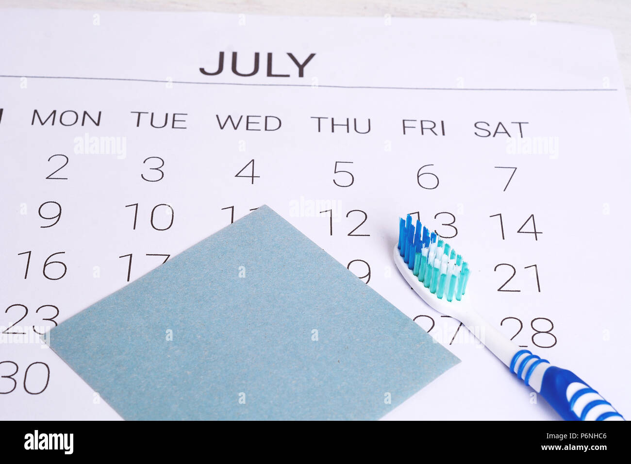 Calendar with a marked date and toothbrush to remind dentist ...