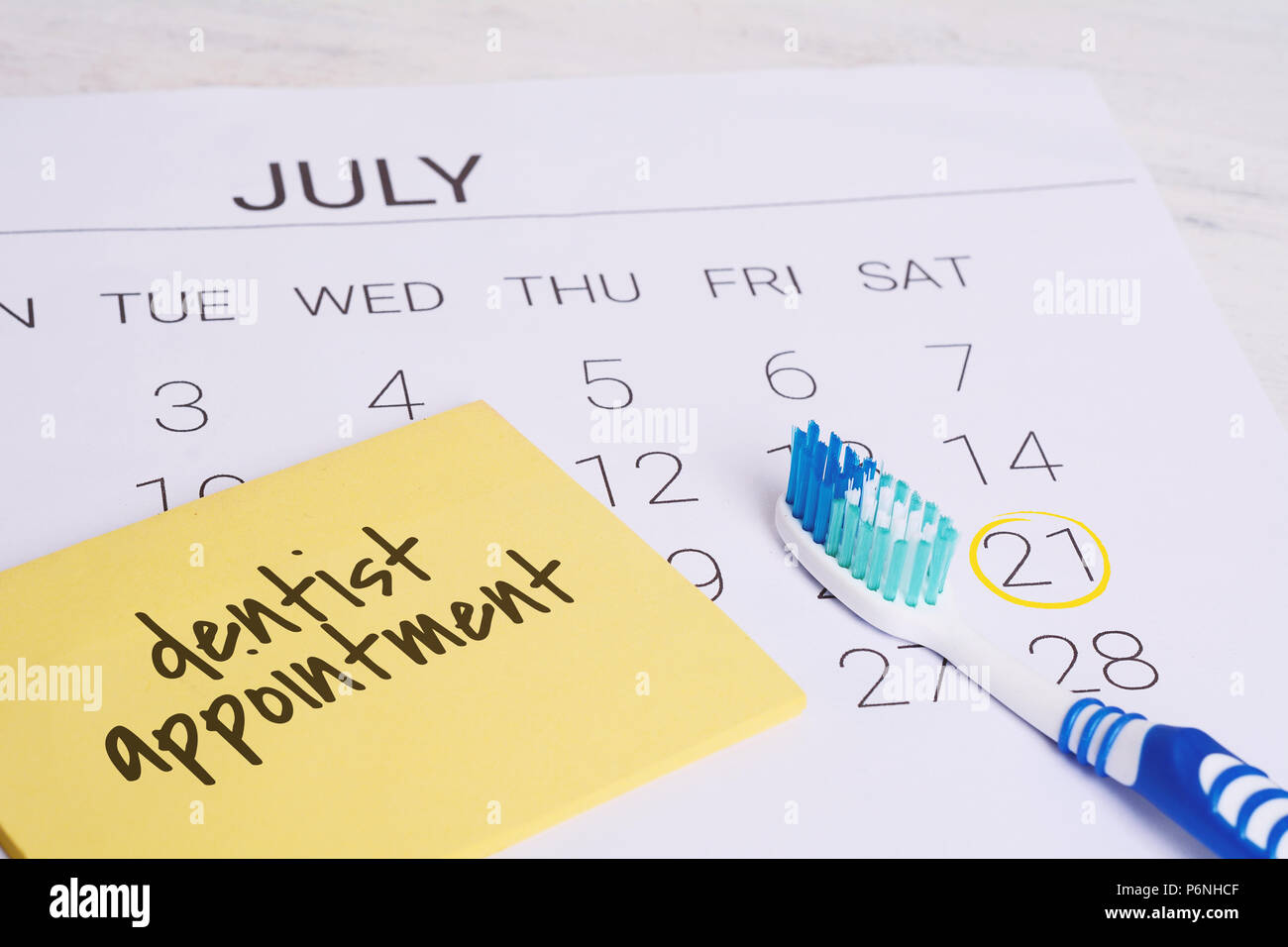 Calendar with a marked date and toothbrush to remind dentist ...