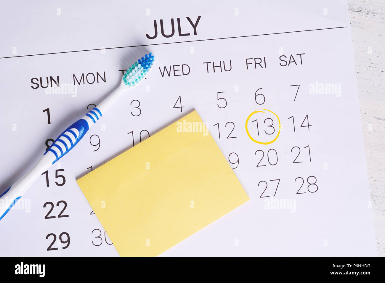 Calendar with a marked date and toothbrush to remind dentist ...