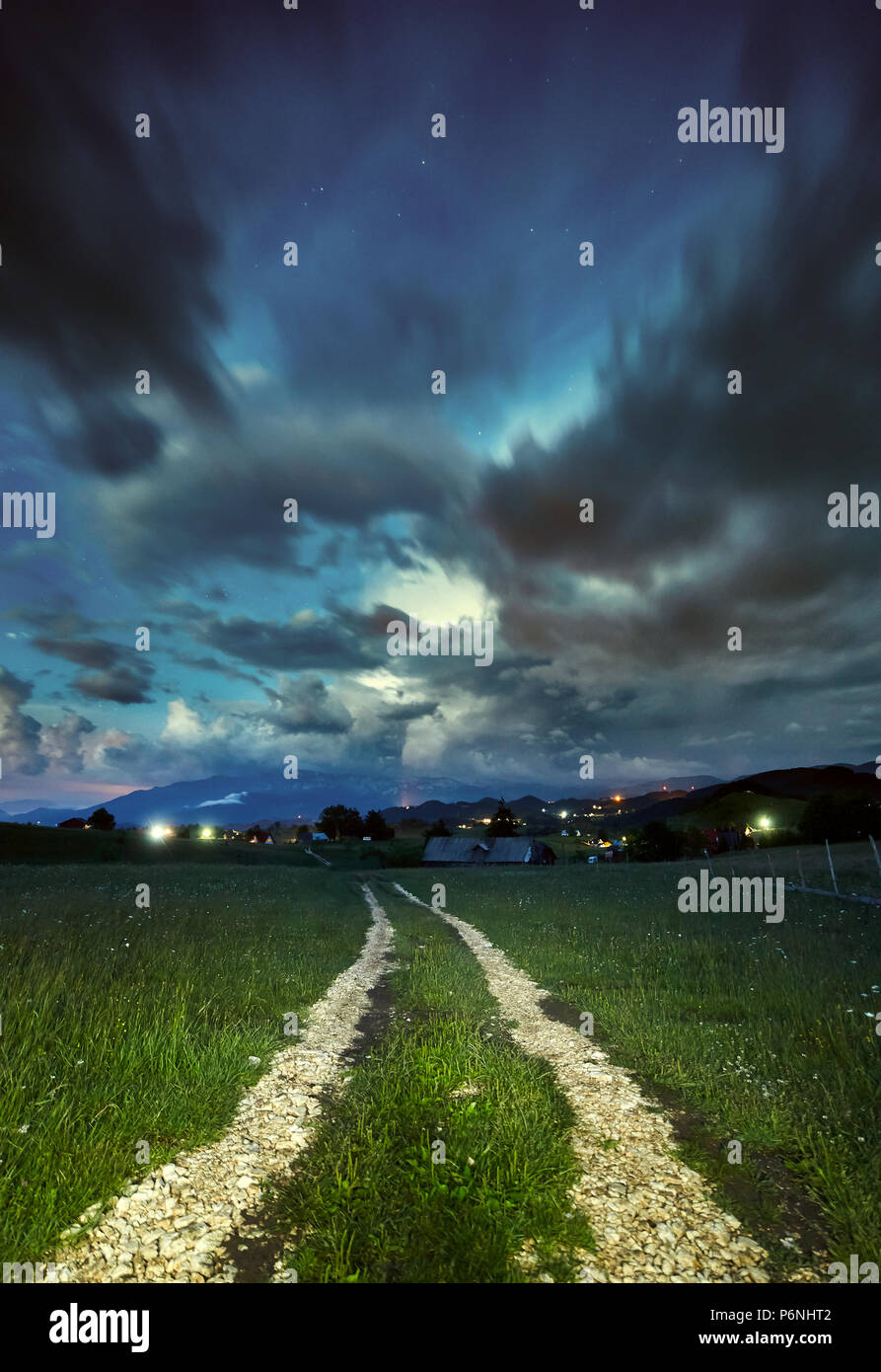 Landscape with night sky and a dirt road Stock Photo - Alamy