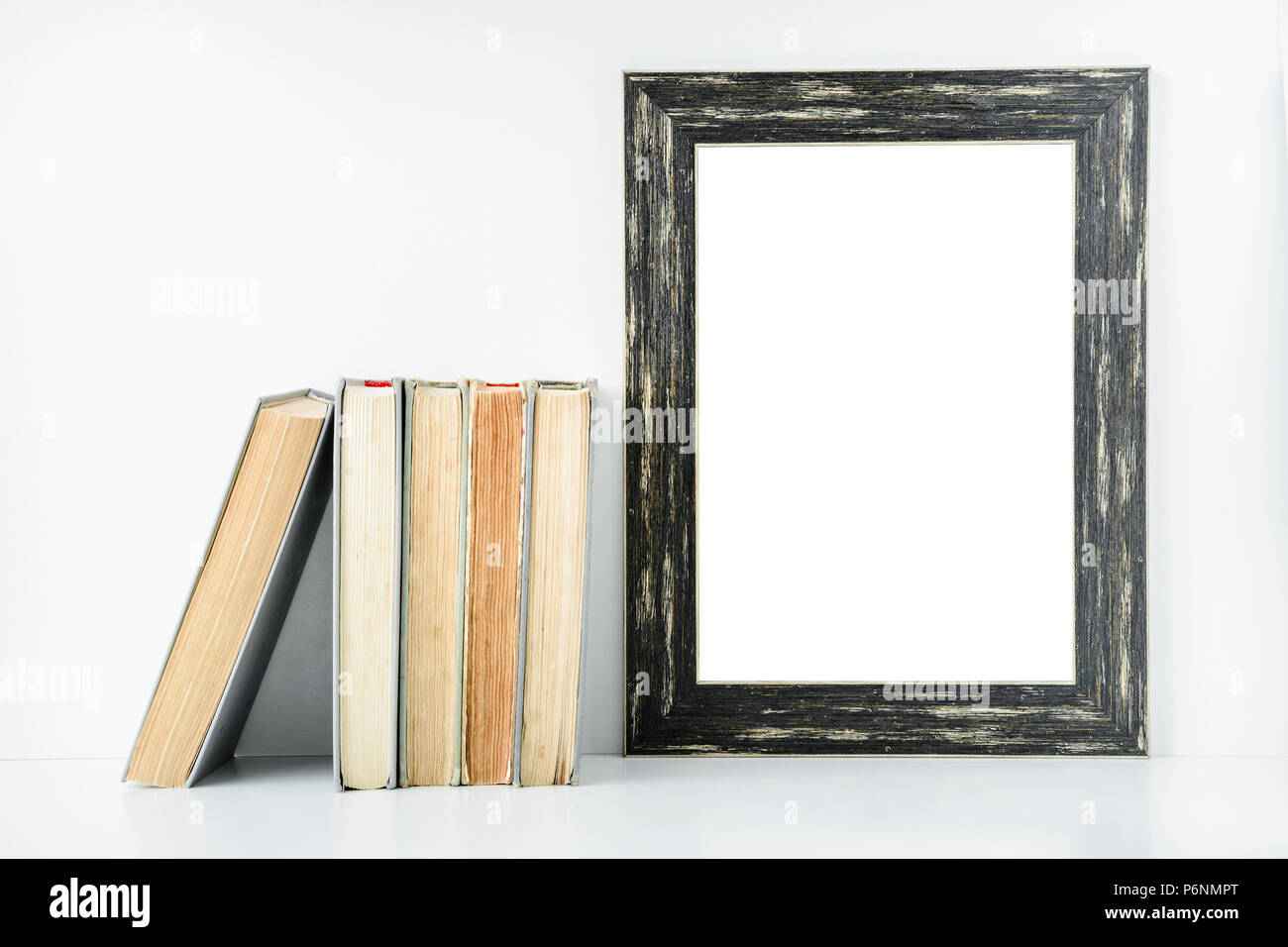 empty black frame and old books on a white background. Layout for ...